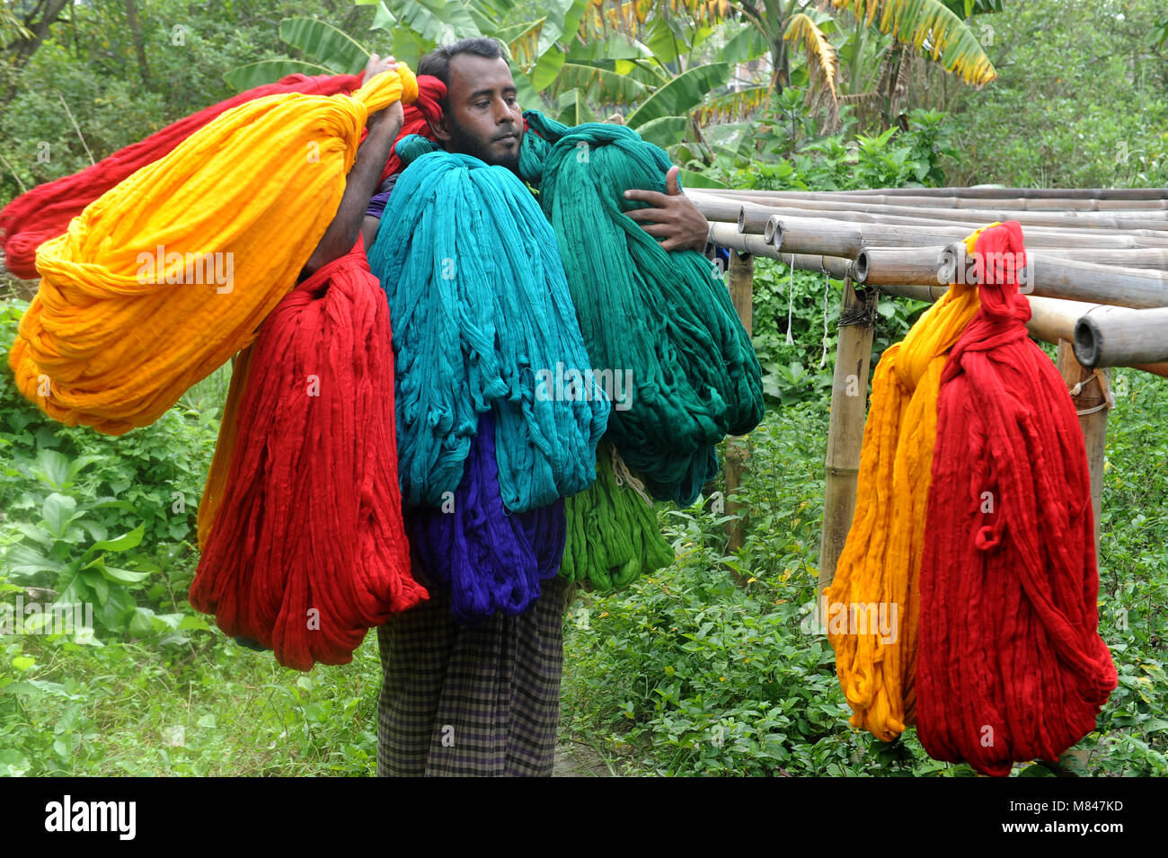 DHAKA, BANGLADESH - AUGUST 29, 2016: A worker weaves cloth at a ...
