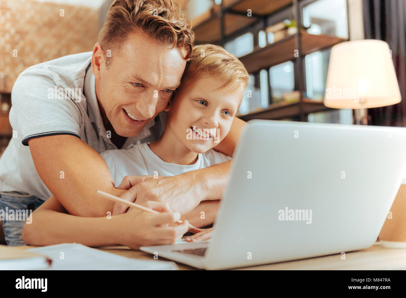 Joyful caring man hugging his son Stock Photo - Alamy