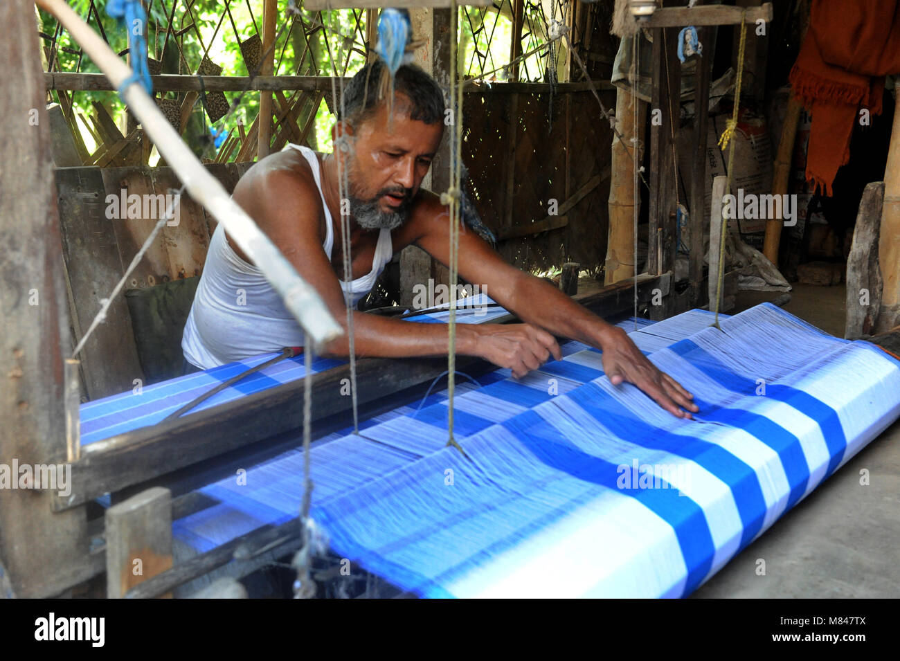 DHAKA, BANGLADESH - AUGUST 29, 2016: A worker weaves cloth at a ...