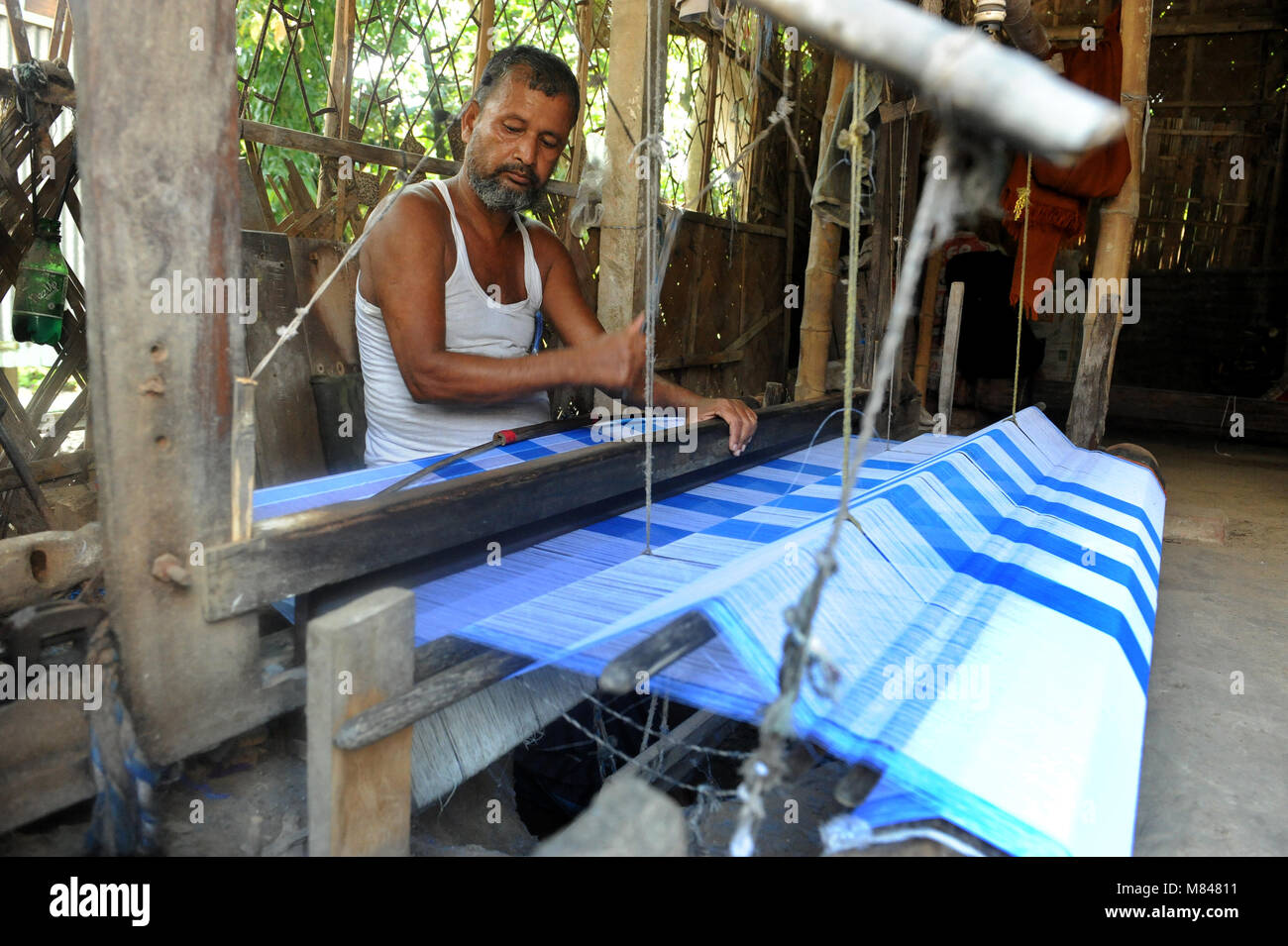 DHAKA, BANGLADESH - AUGUST 29, 2016: A worker weaves cloth at a ...