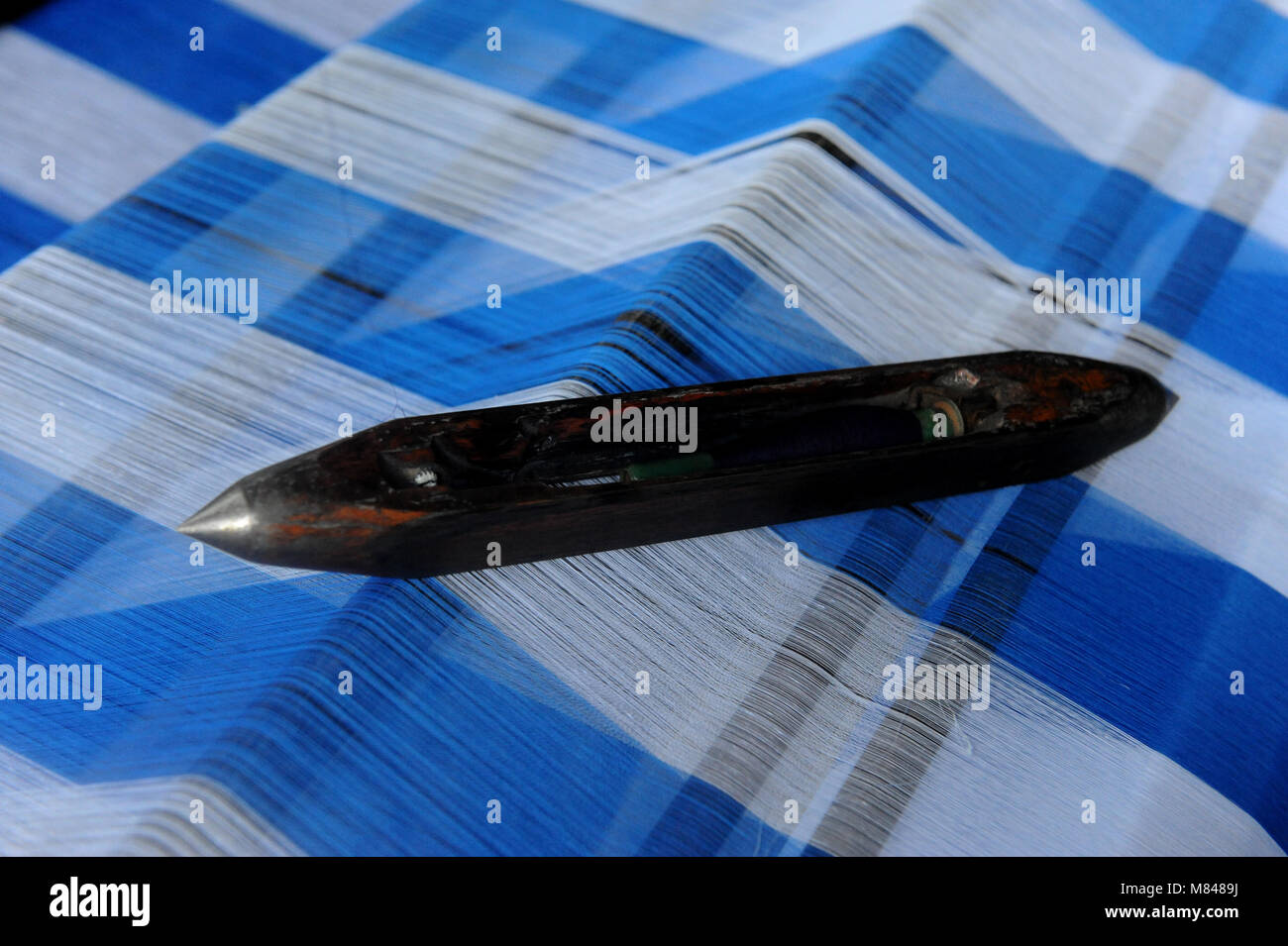 DHAKA, BANGLADESH - AUGUST 29, 2016: A worker weaves cloth at a ...