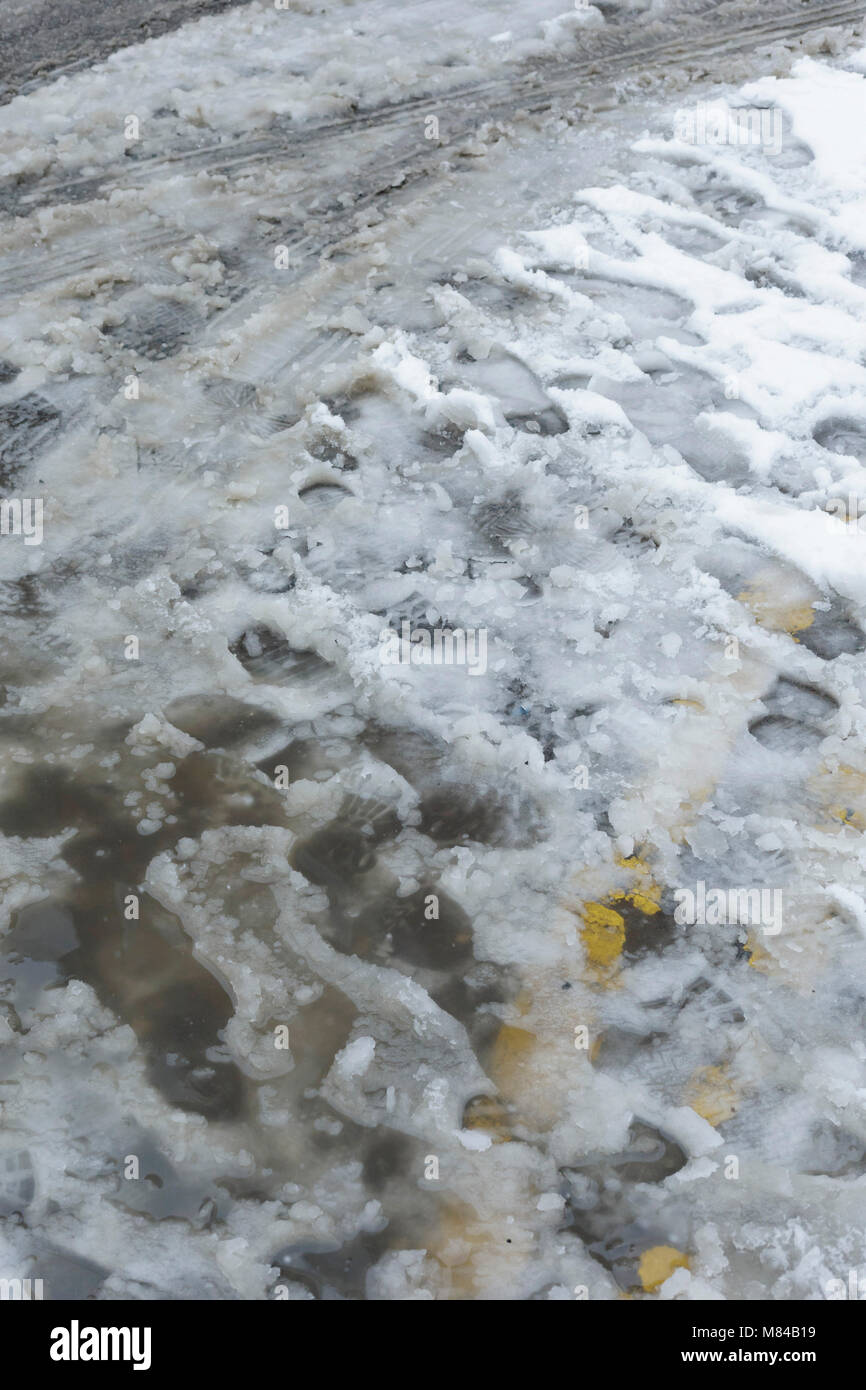 Partially visible Double Yellow Lines under sludge, sleet and snow on ...