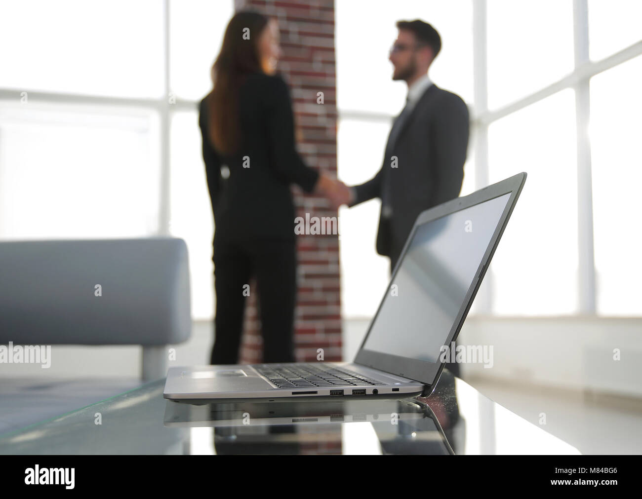 laptop on the desk, background handshake Stock Photo - Alamy