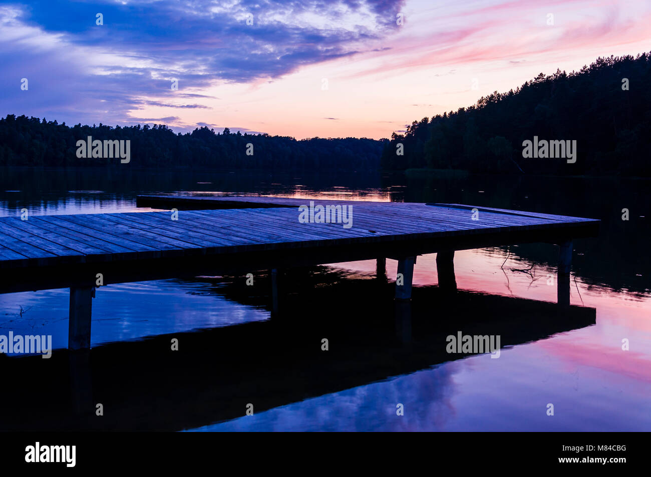 Sunset Waterscape view with lake beach pier. Clouds above forest ...
