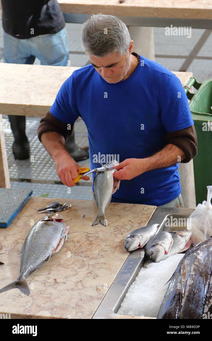 A market trader descaling sea bream for their customers at the local ...
