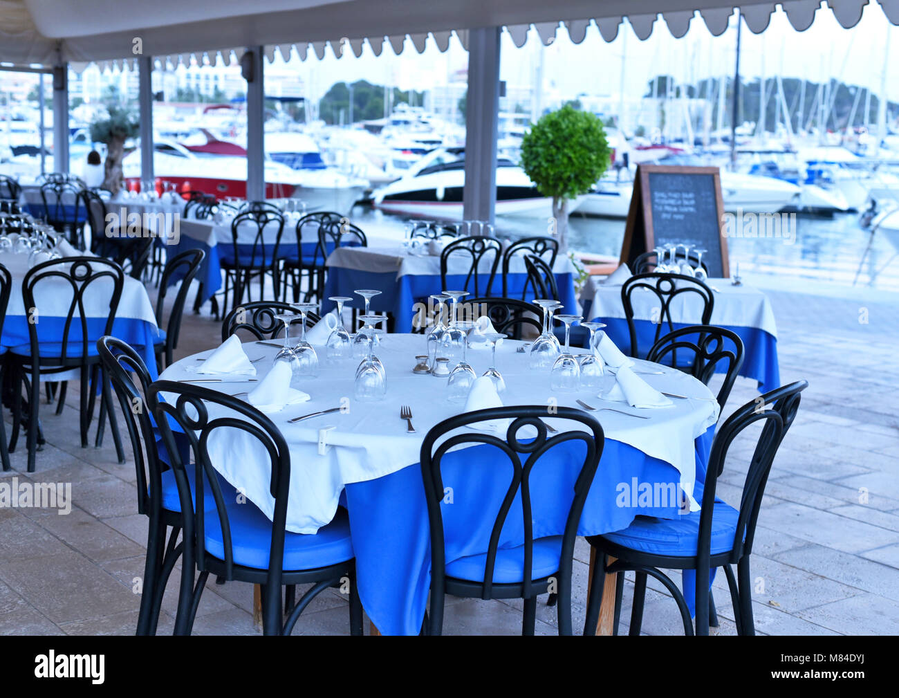 Harbor restaurant with empty seats and table setting. dinner tables at ...