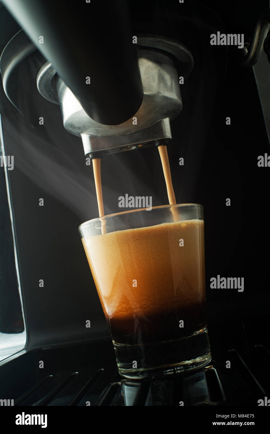 Espresso pouring from coffee machine. Professional coffee brewing Stock ...
