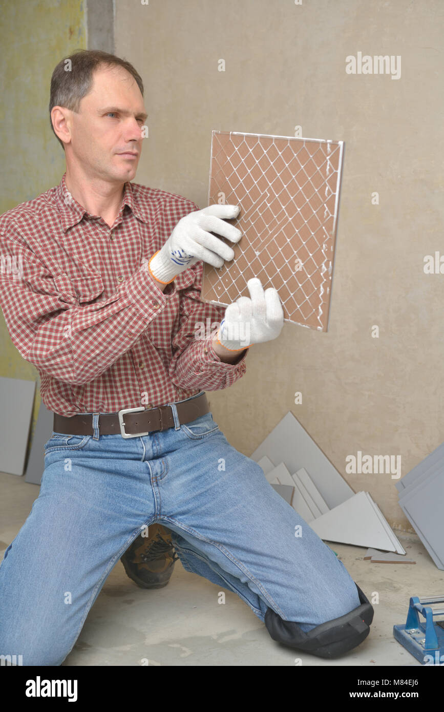 Tiler check ceramic tile before installs it on a floor Stock Photo - Alamy
