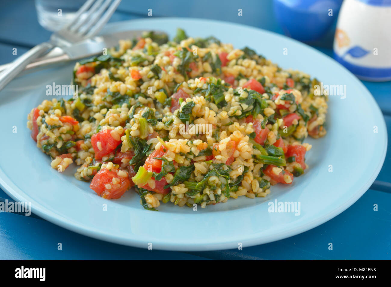 Bulgur and vegetable pilaf with spinach on a plate Stock Photo - Alamy