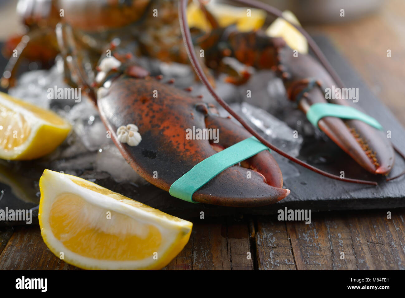 Clawed lobster on a table before cooking. Focus on claws Stock Photo ...