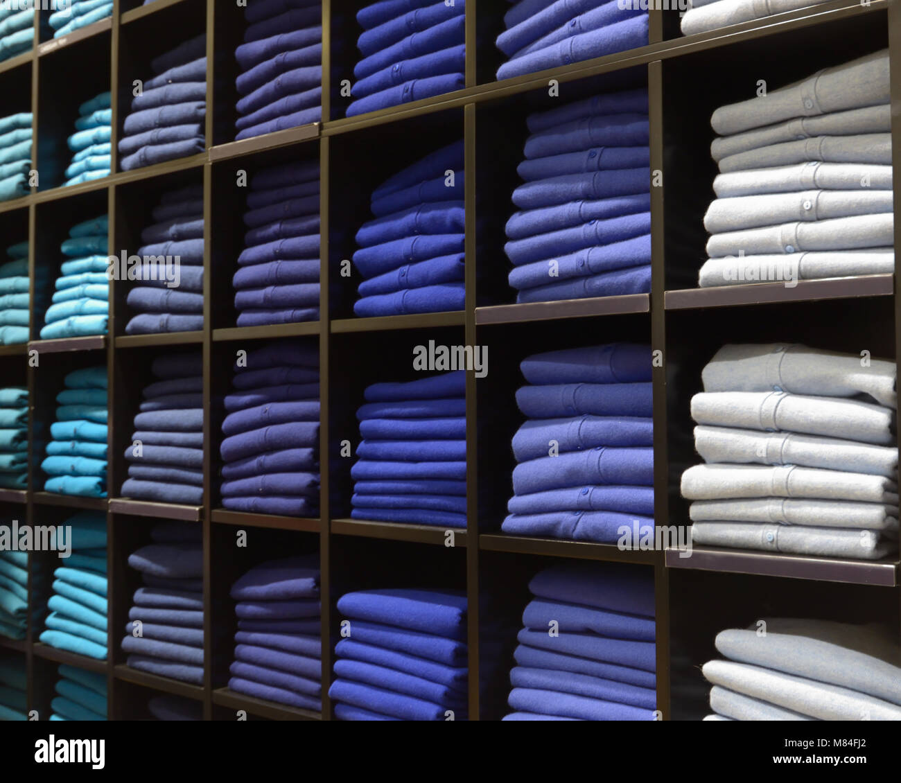 Blue colored clothes on shelves in a shop Stock Photo - Alamy