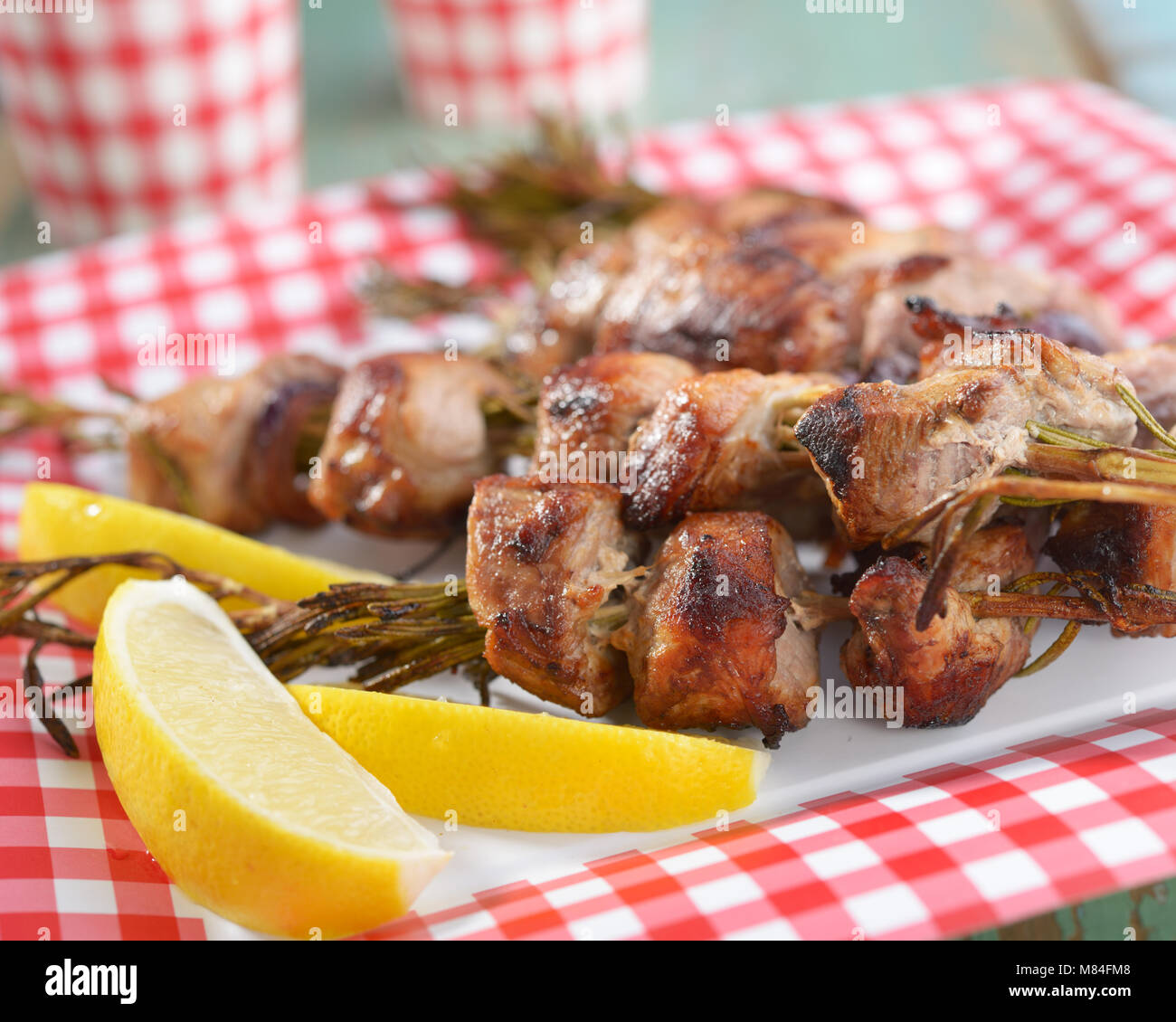 Souvlaki on rosemary sticks with lemon on a paper plate Stock Photo - Alamy