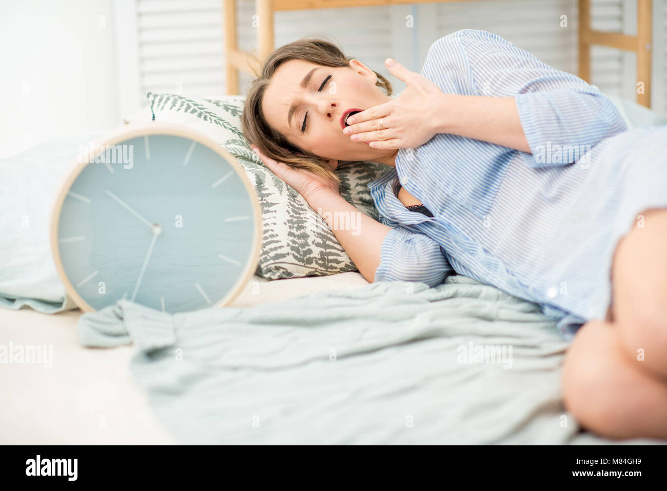 Woman sleeping with clock on the bed Stock Photo - Alamy