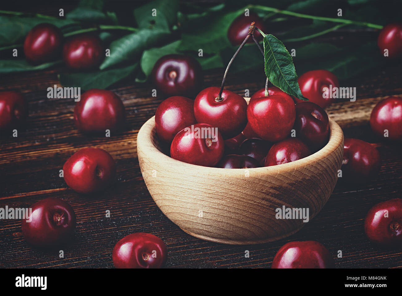 Fresh cherries in bowl on old brown wooden table(selective focus Stock ...