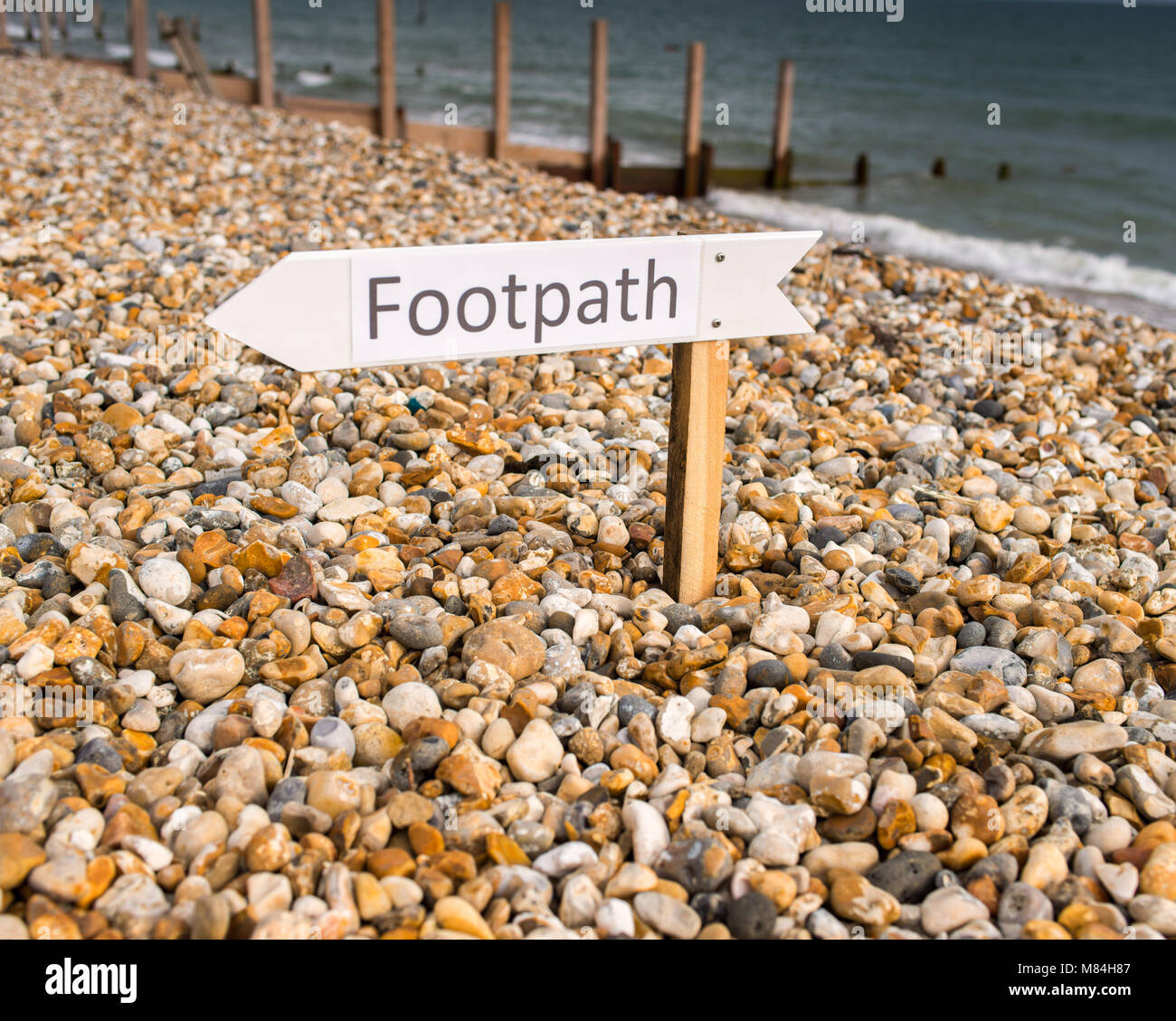 low sign on pebble beach pointing the way with the sea behind Stock ...