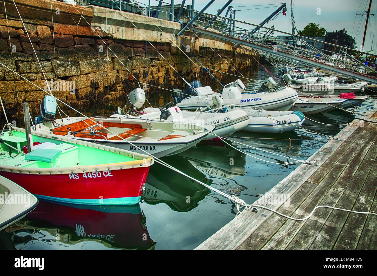 Small boats tied to dock by ropes for protection Stock Photo - Alamy