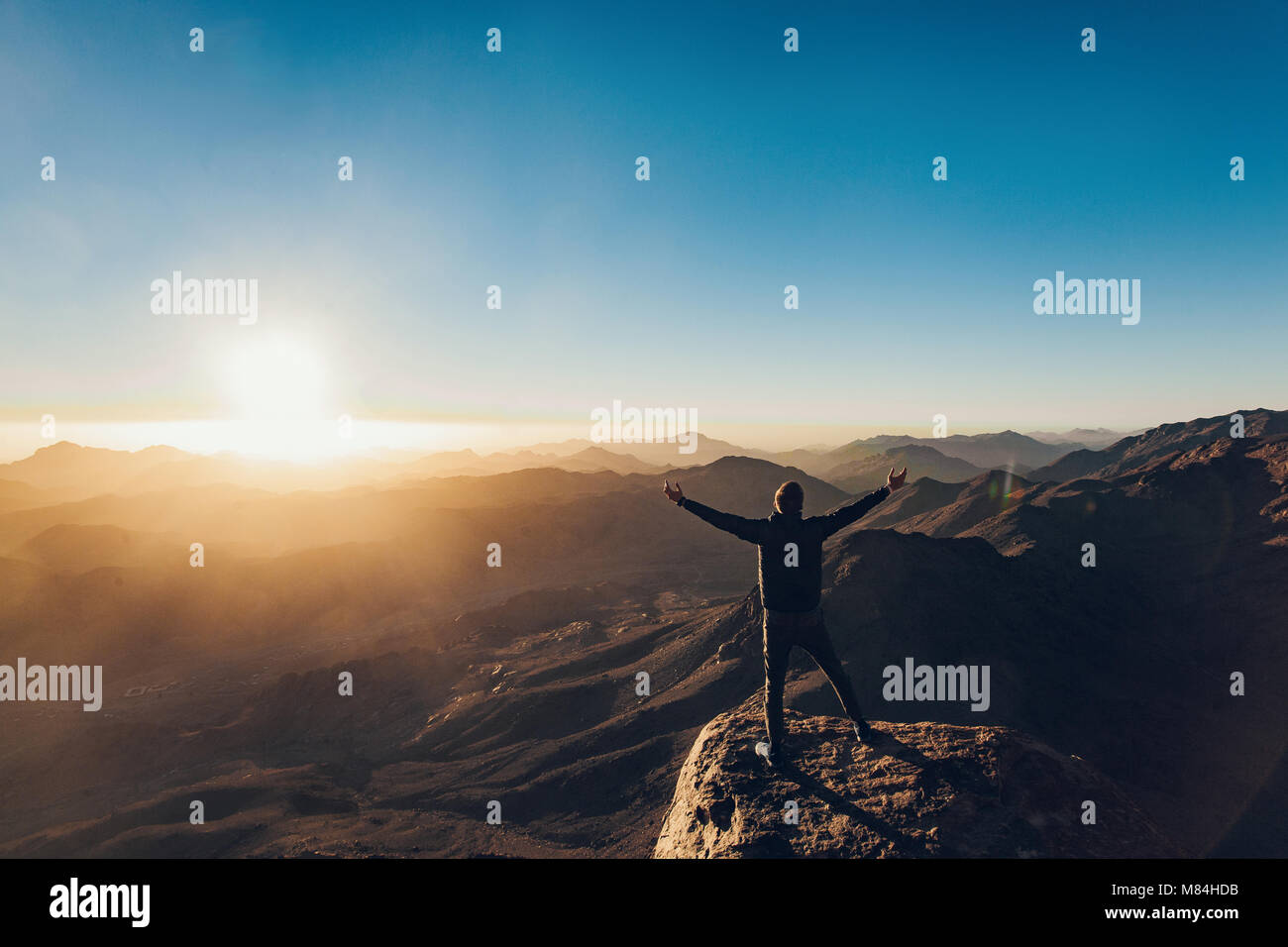 Man stands facing the rising sun and meditates on Mount Sinai in Egypt ...