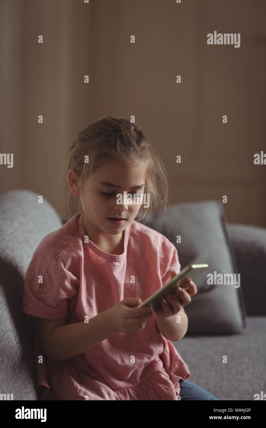 Little girl using mobile phone in living room Stock Photo - Alamy