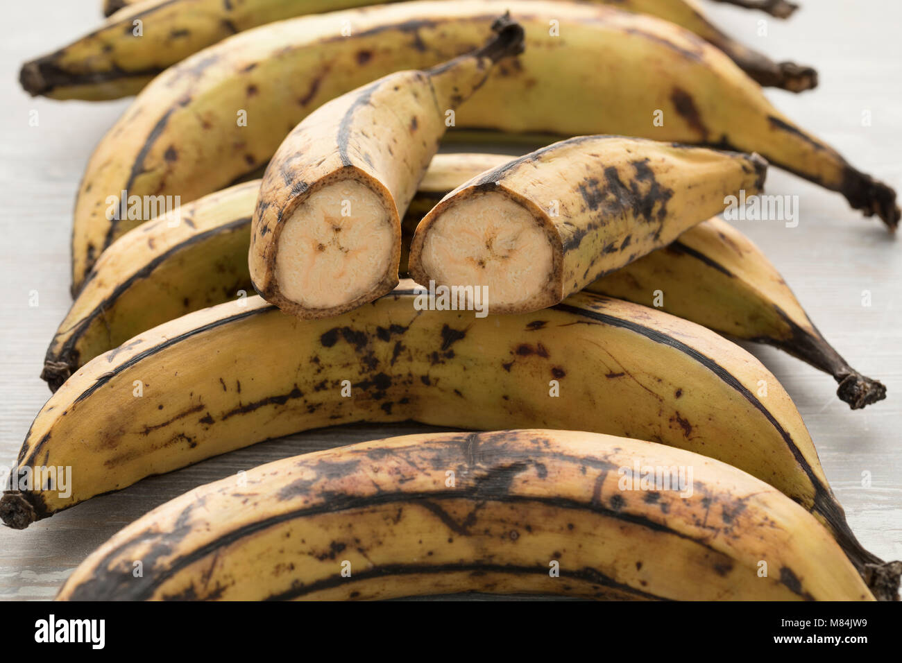 Whole and half fresh raw yellow plantains Stock Photo - Alamy