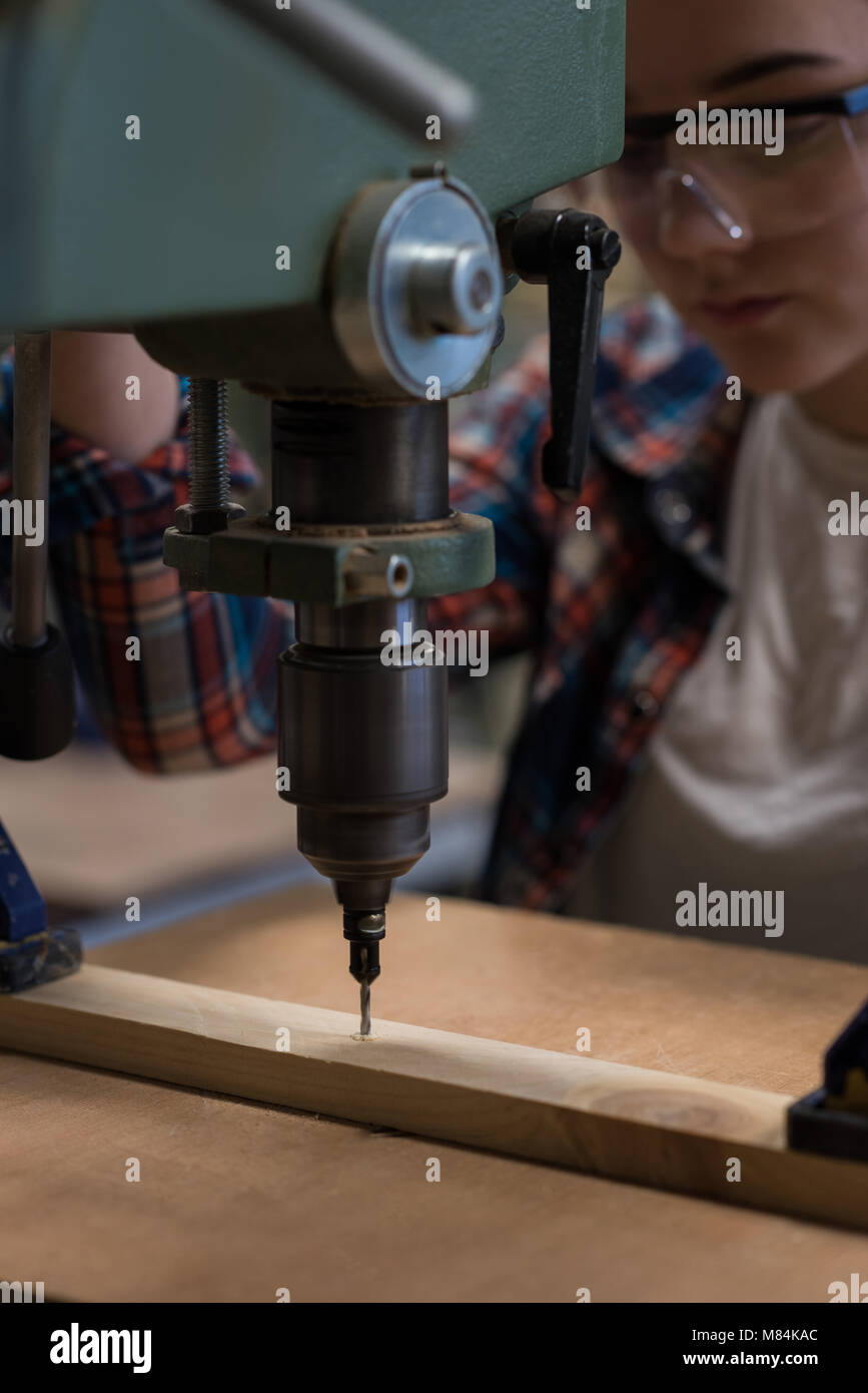 Female carpenter using vertical drill machine Stock Photo - Alamy