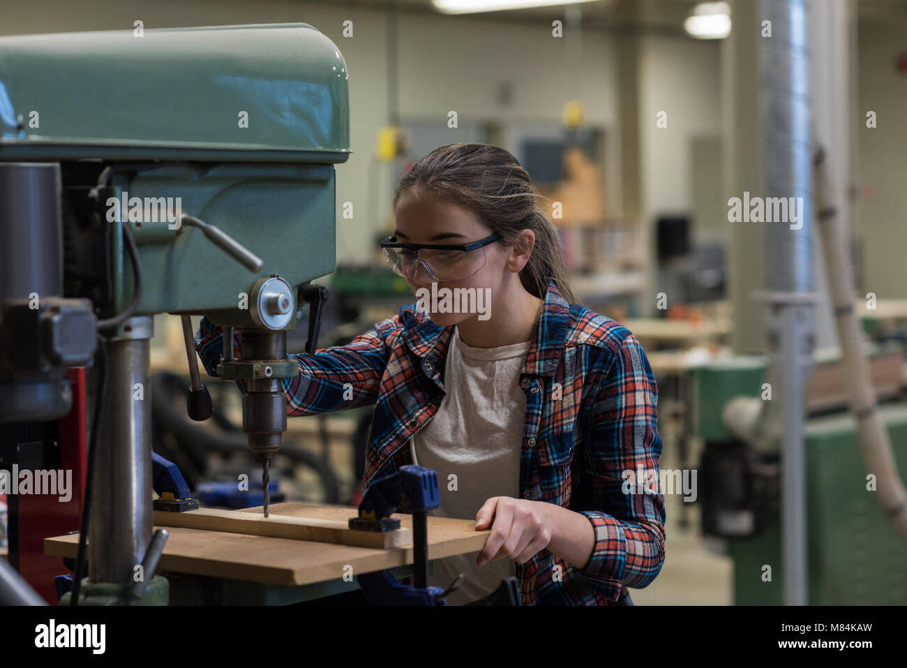 Female carpenter using vertical drill machine Stock Photo - Alamy