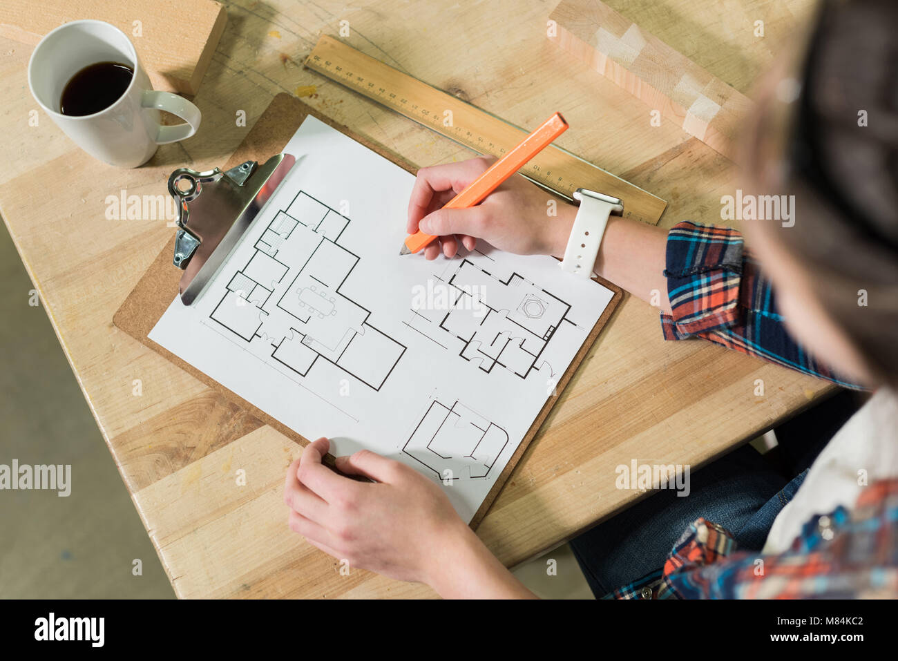 Female carpenter drawing a plan on clipboard Stock Photo - Alamy