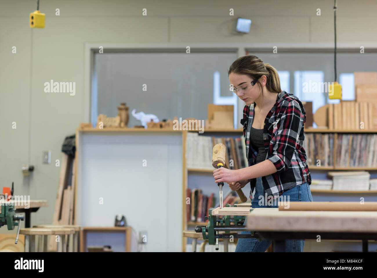 Female carpenter using chisel with hammer on a piece of wood Stock ...