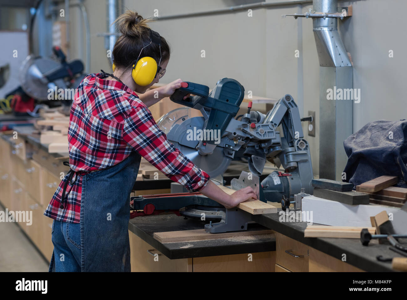 Female carpenter using grinder cutting machine Stock Photo - Alamy