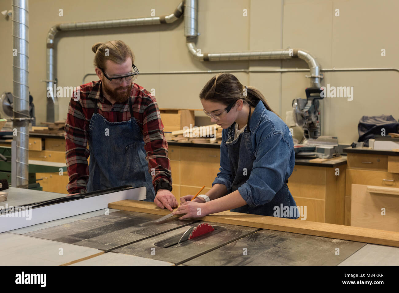 Male and female carpenters working together Stock Photo - Alamy