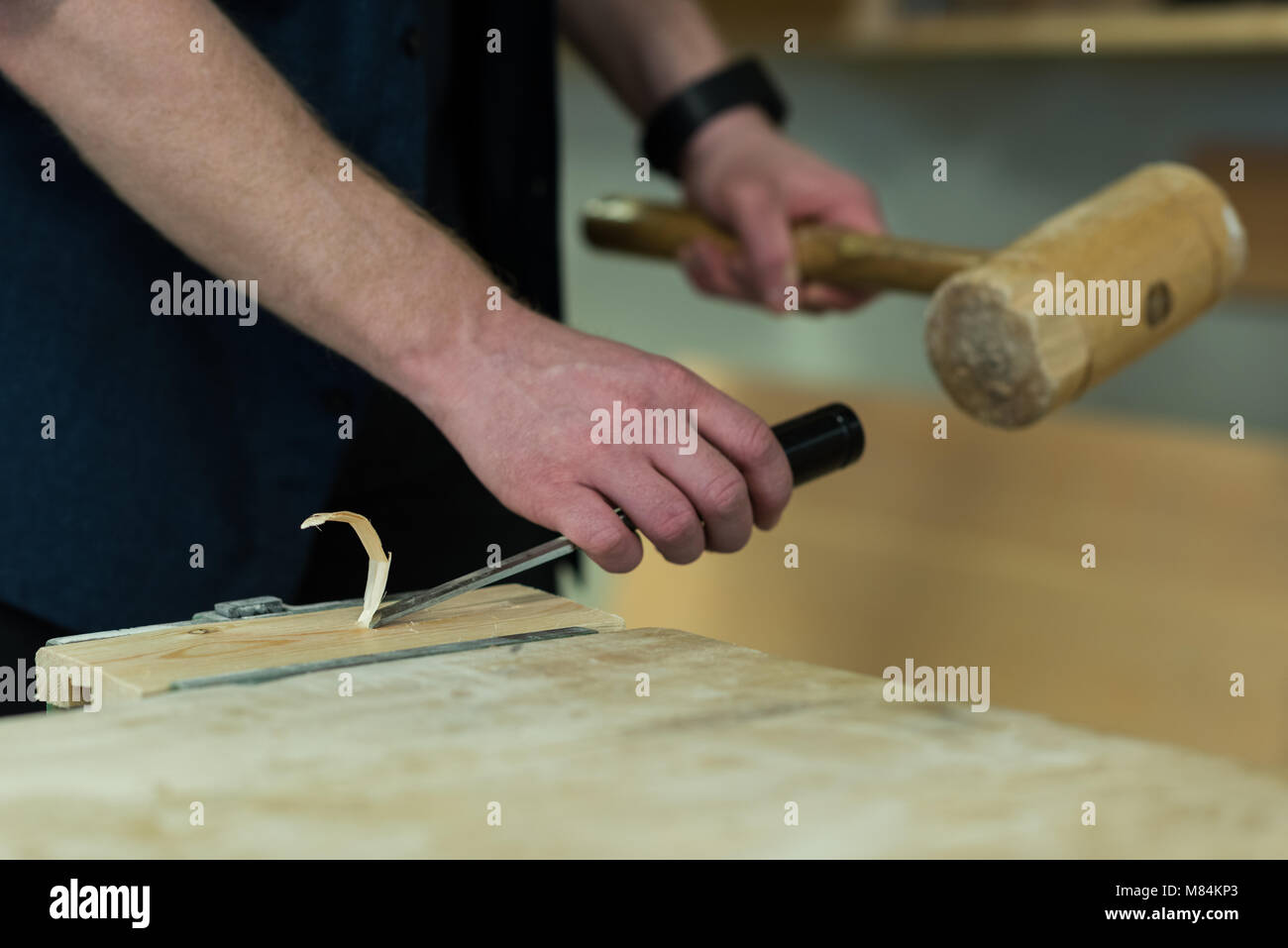 Male carpenter using chisel with hammer on a piece of wood Stock Photo ...