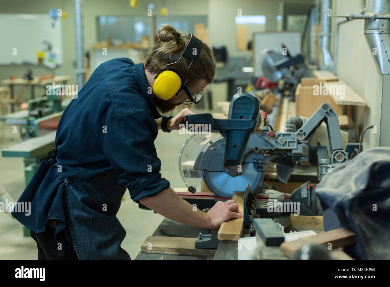 Male carpenter using grinder cutting machine Stock Photo - Alamy