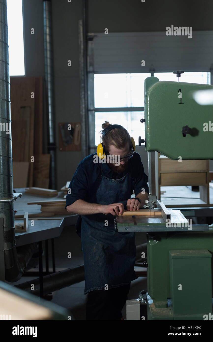 Male carpenter using vertical cutter machine Stock Photo - Alamy