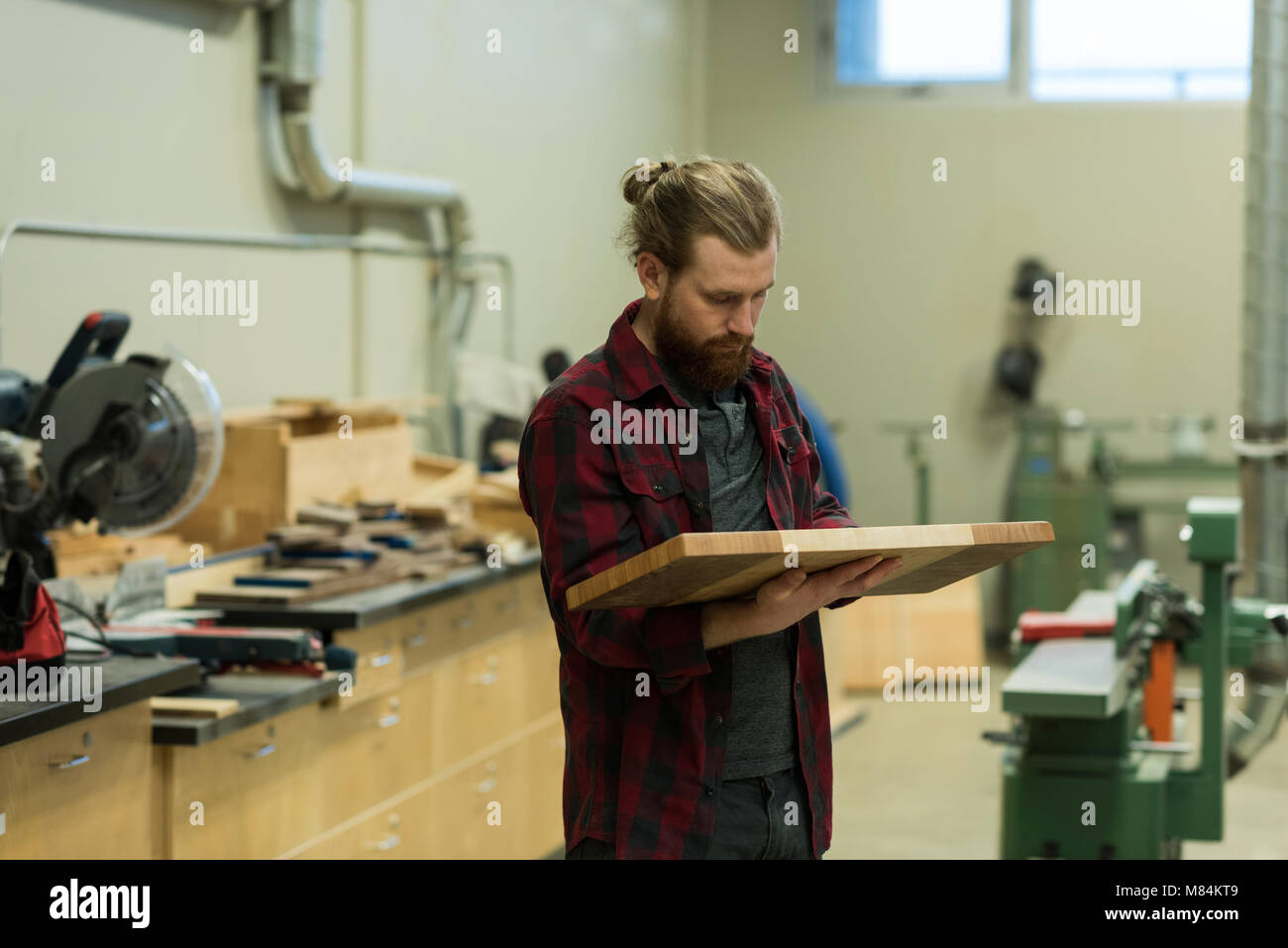 Male carpenter examining a wood furniture at workshop Stock Photo - Alamy