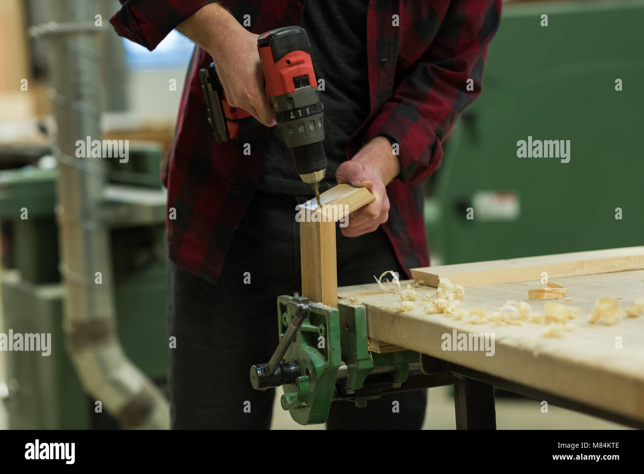Male carpenter using drill machine at workshop Stock Photo - Alamy