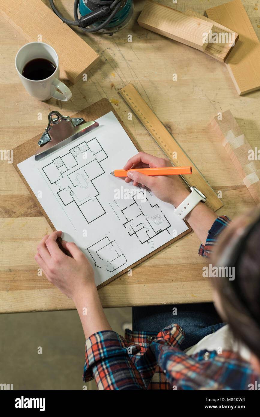 Female carpenter drawing a plan on clipboard Stock Photo - Alamy