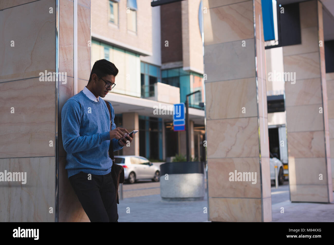 Businessman using mobile phone outside office premises Stock Photo - Alamy