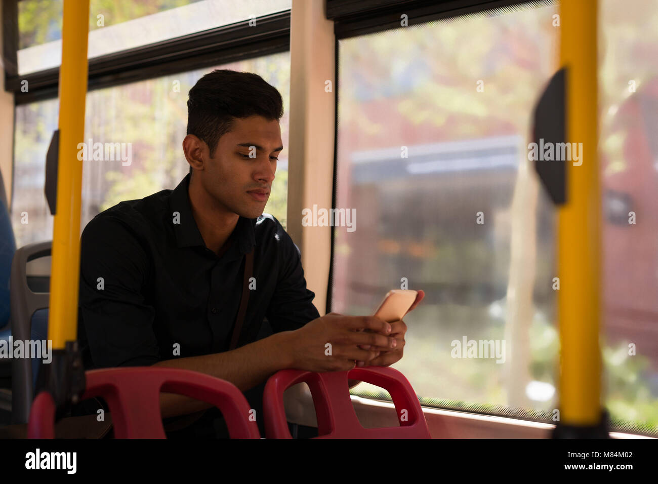 Man on bus using phone hi-res stock photography and images - Alamy