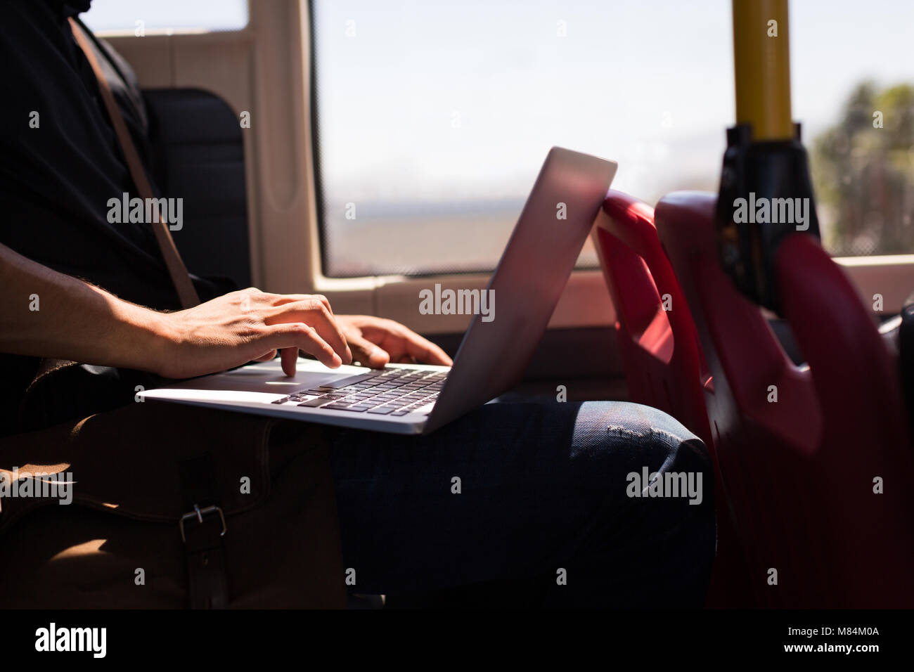 Businessman using laptop while travelling in bus Stock Photo - Alamy
