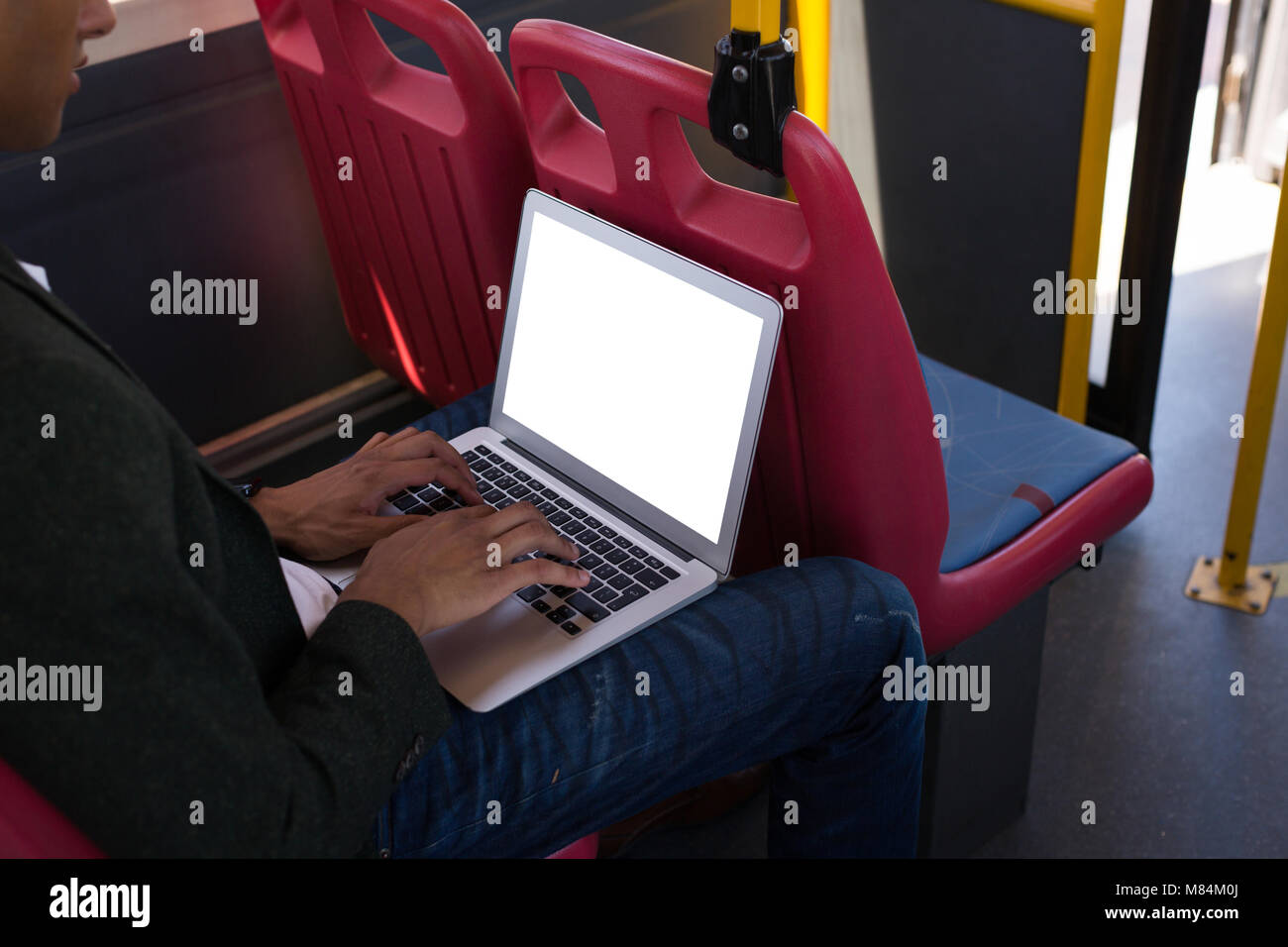 Businessman using laptop while travelling in bus Stock Photo - Alamy