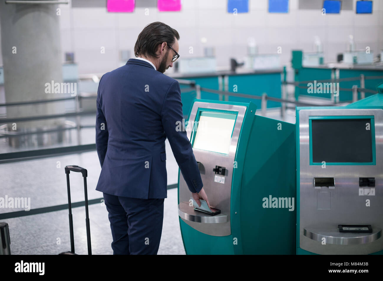 Businessman using airline ticket machine Stock Photo - Alamy