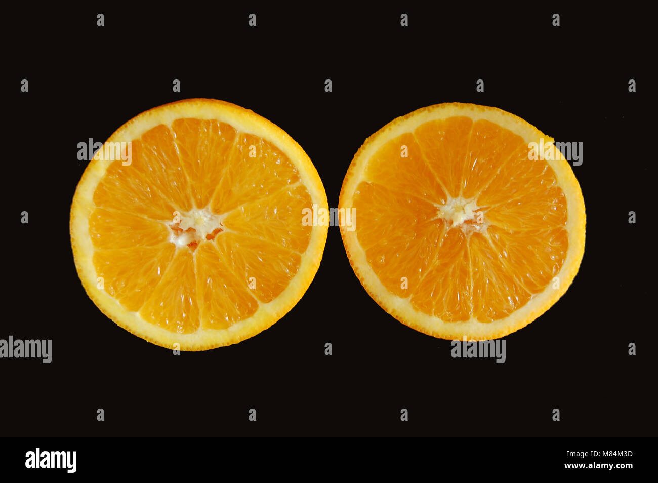 a split orange half isolated on black background Stock Photo - Alamy