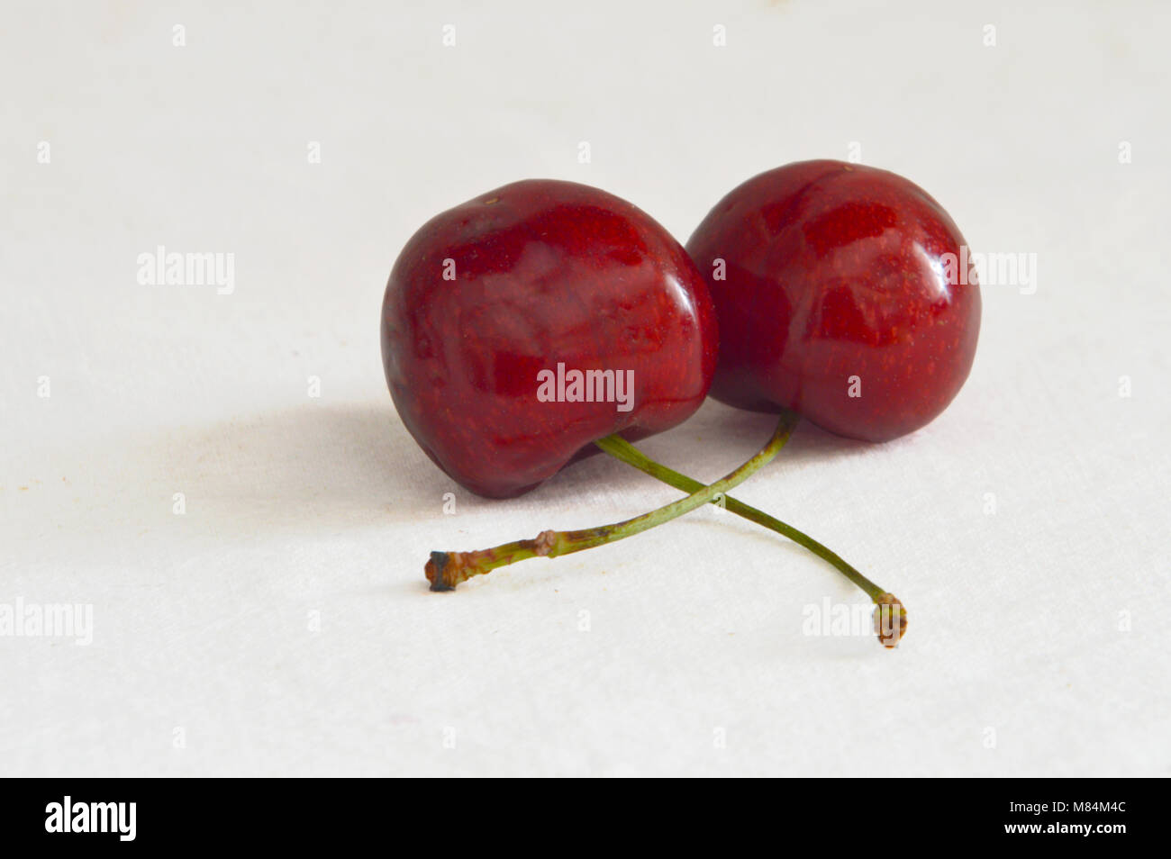 two cherries isolated on white background Stock Photo - Alamy