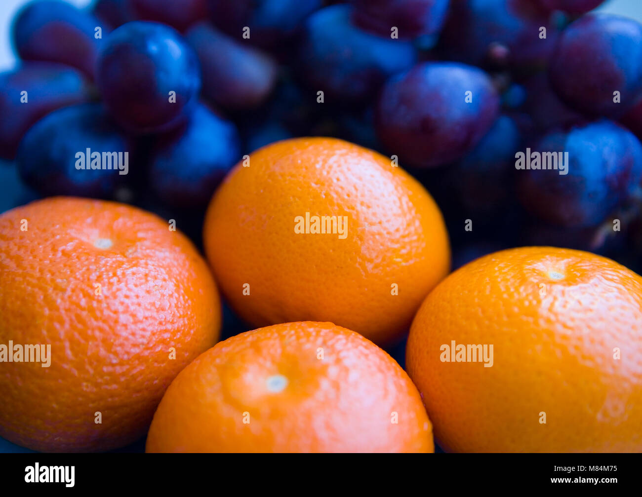 Ripe mandarins and black grapes in the background. Fruit Stock Photo ...