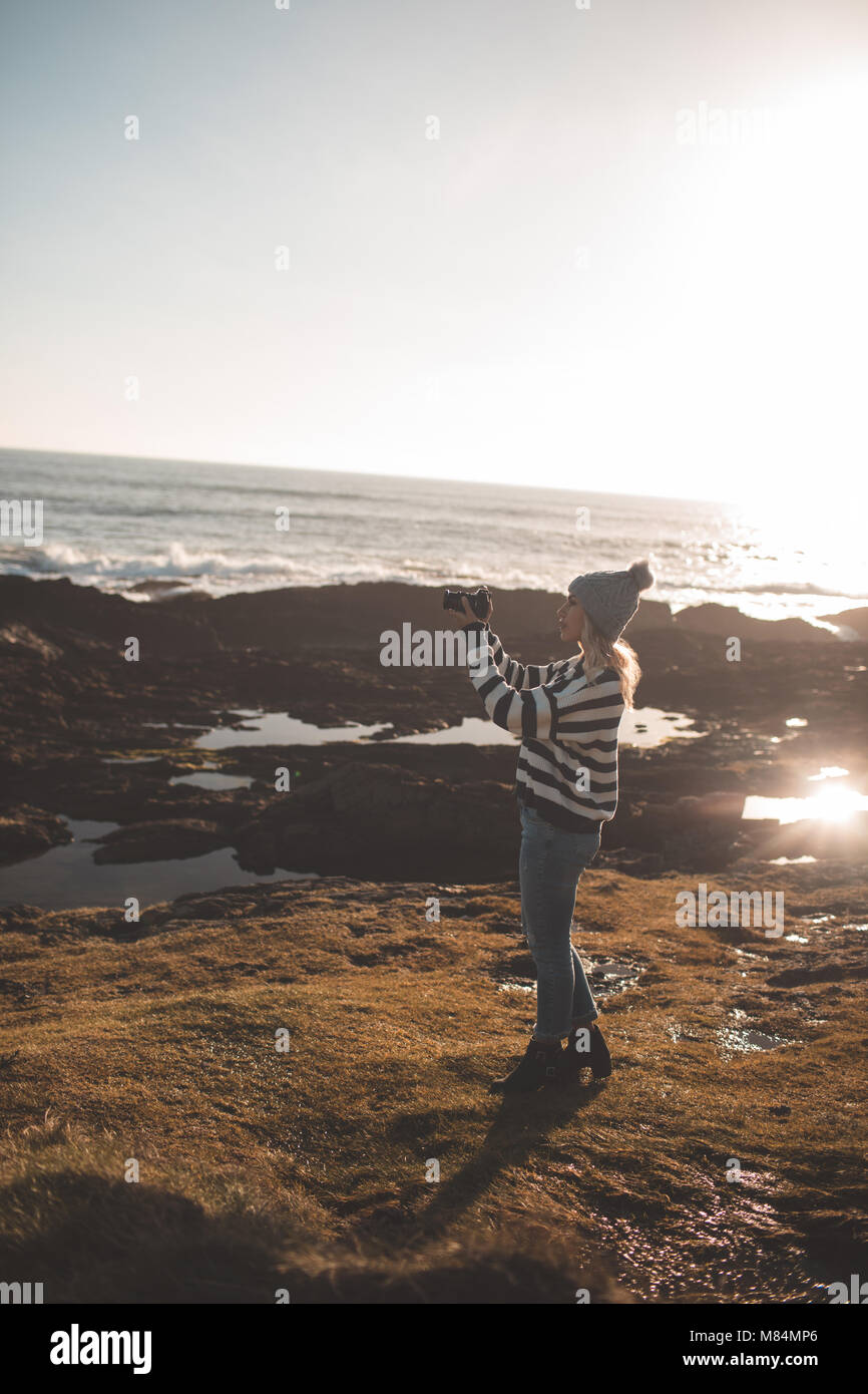 Woman clicking photo with camera Stock Photo - Alamy