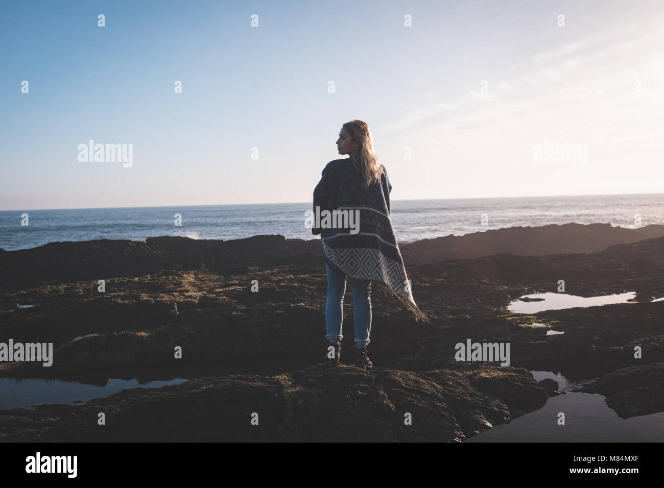 Woman standing over rock on a beach Stock Photo - Alamy