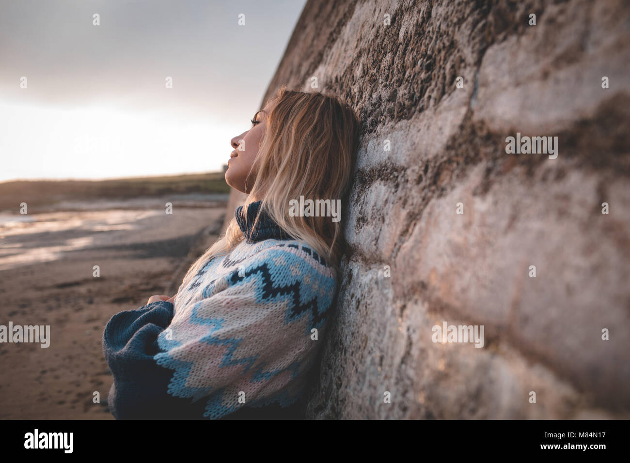 Woman leaning against wall hi-res stock photography and images - Alamy