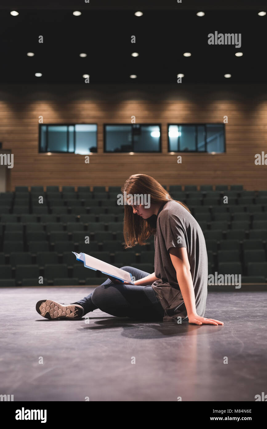 Female actress reading script on stage Stock Photo - Alamy