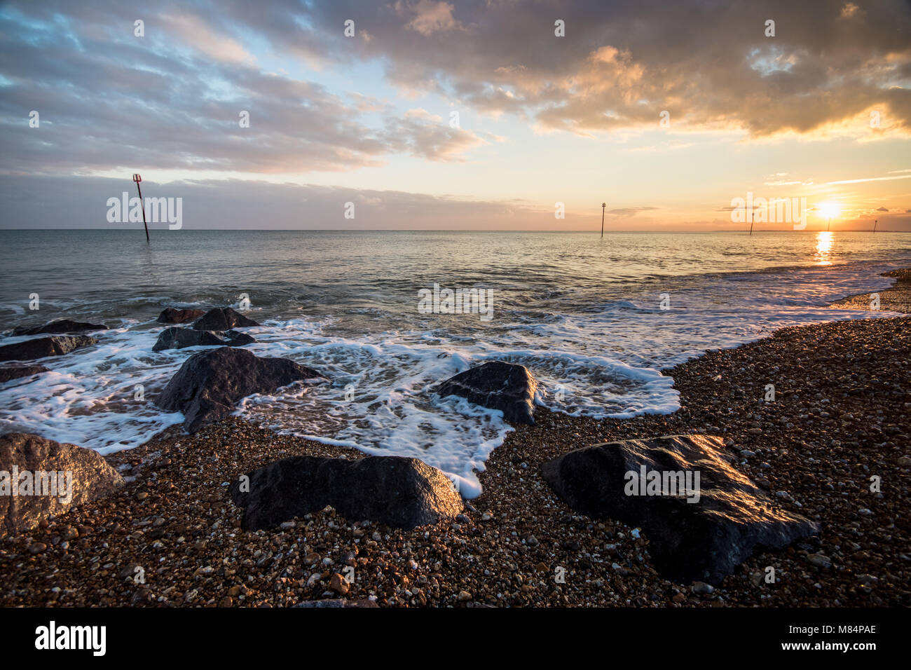 Sunset on a pebble beach with views towards Bognor Regis pier, Selsey ...