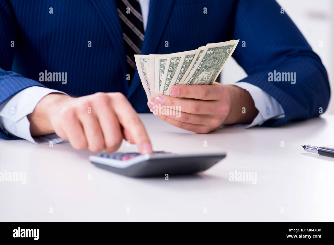 Accountant calculating dollars with calculator in office Stock Photo ...