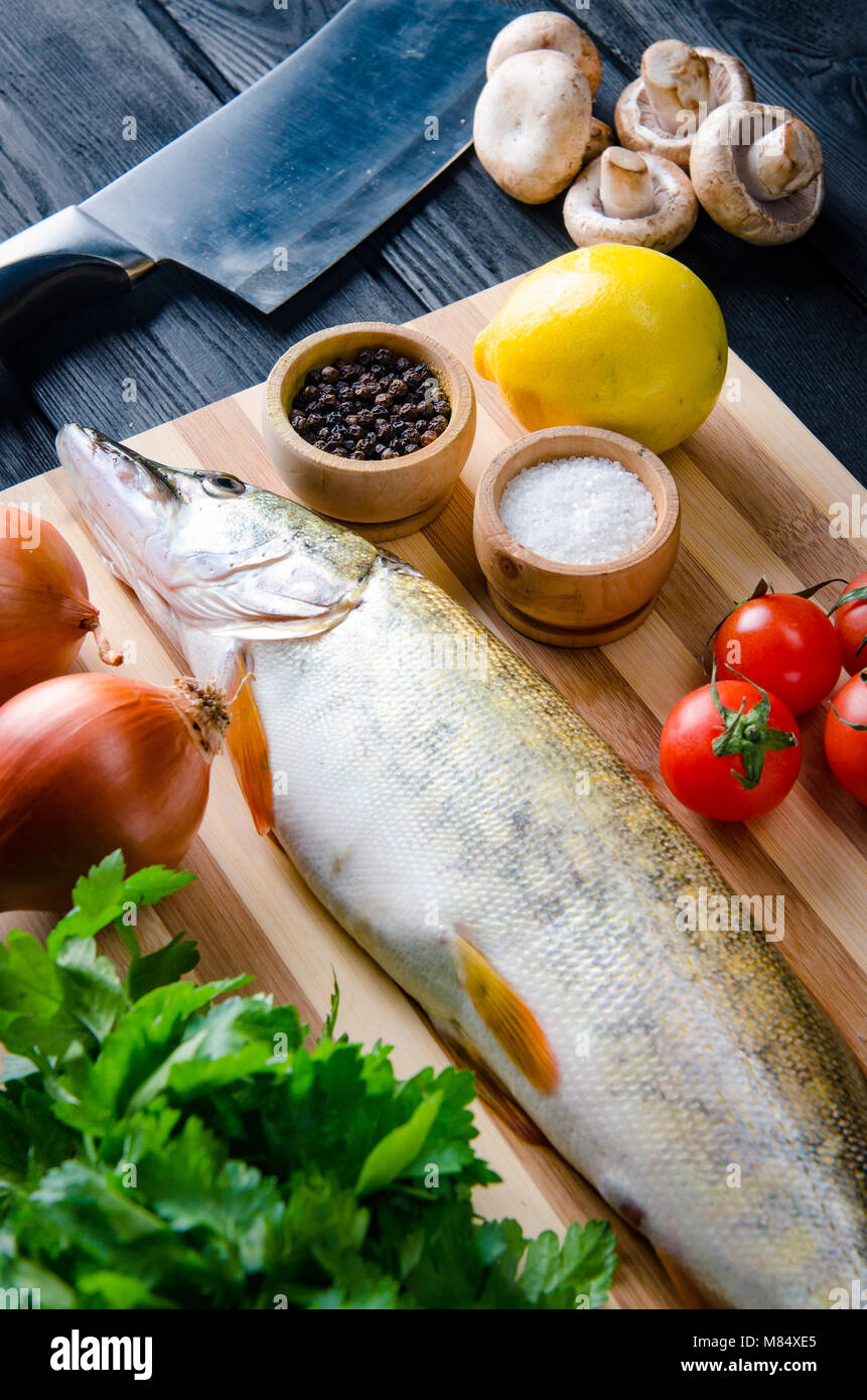 Uncooked fish on cutting board in meal preparation concept Stock Photo ...